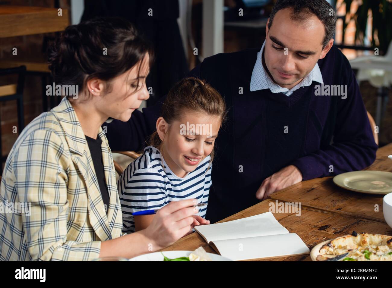 African american daughter doing homework table hi-res stock photography ...