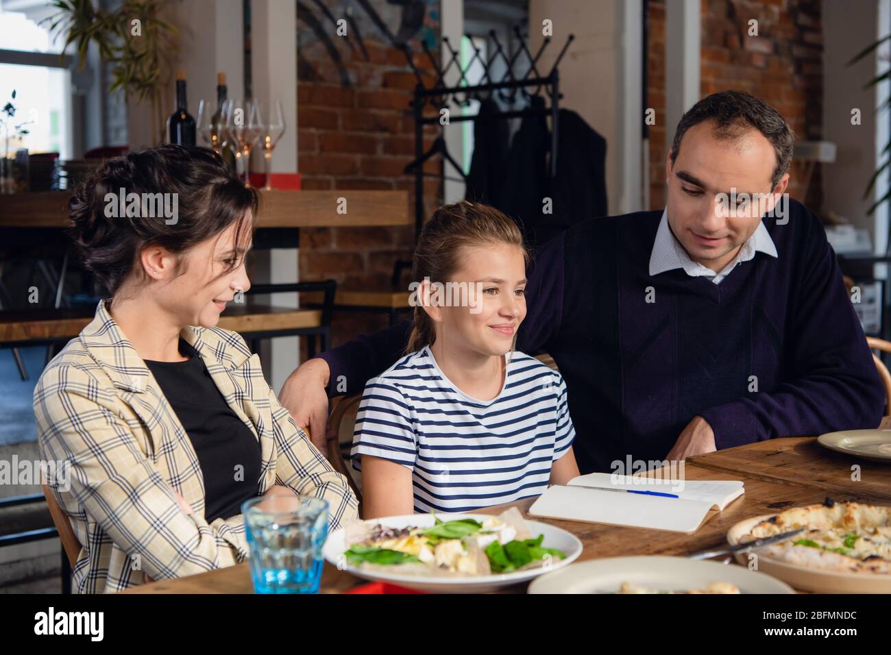 Young parents helping their daughter with her homework Stock Photo - Alamy