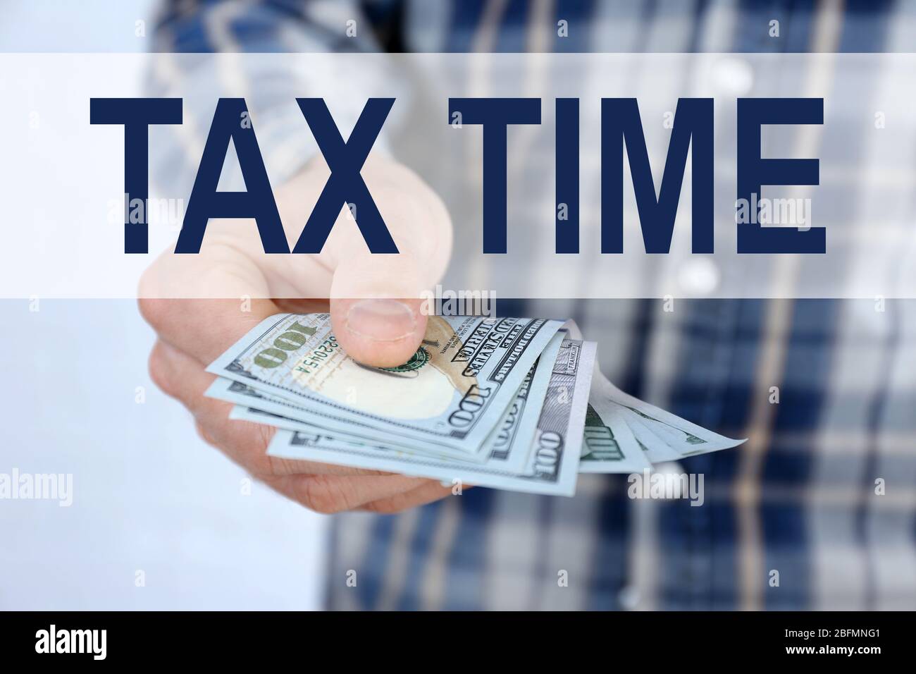 Tax Concept. Man holding dollars in hand Stock Photo - Alamy
