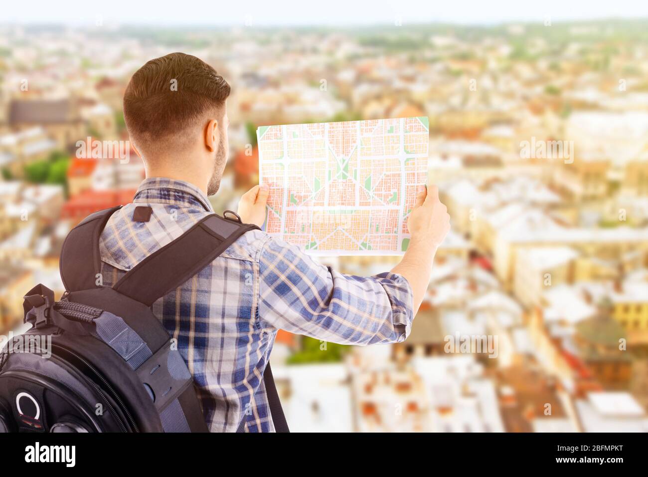Traveler with map on cityscape background Stock Photo - Alamy