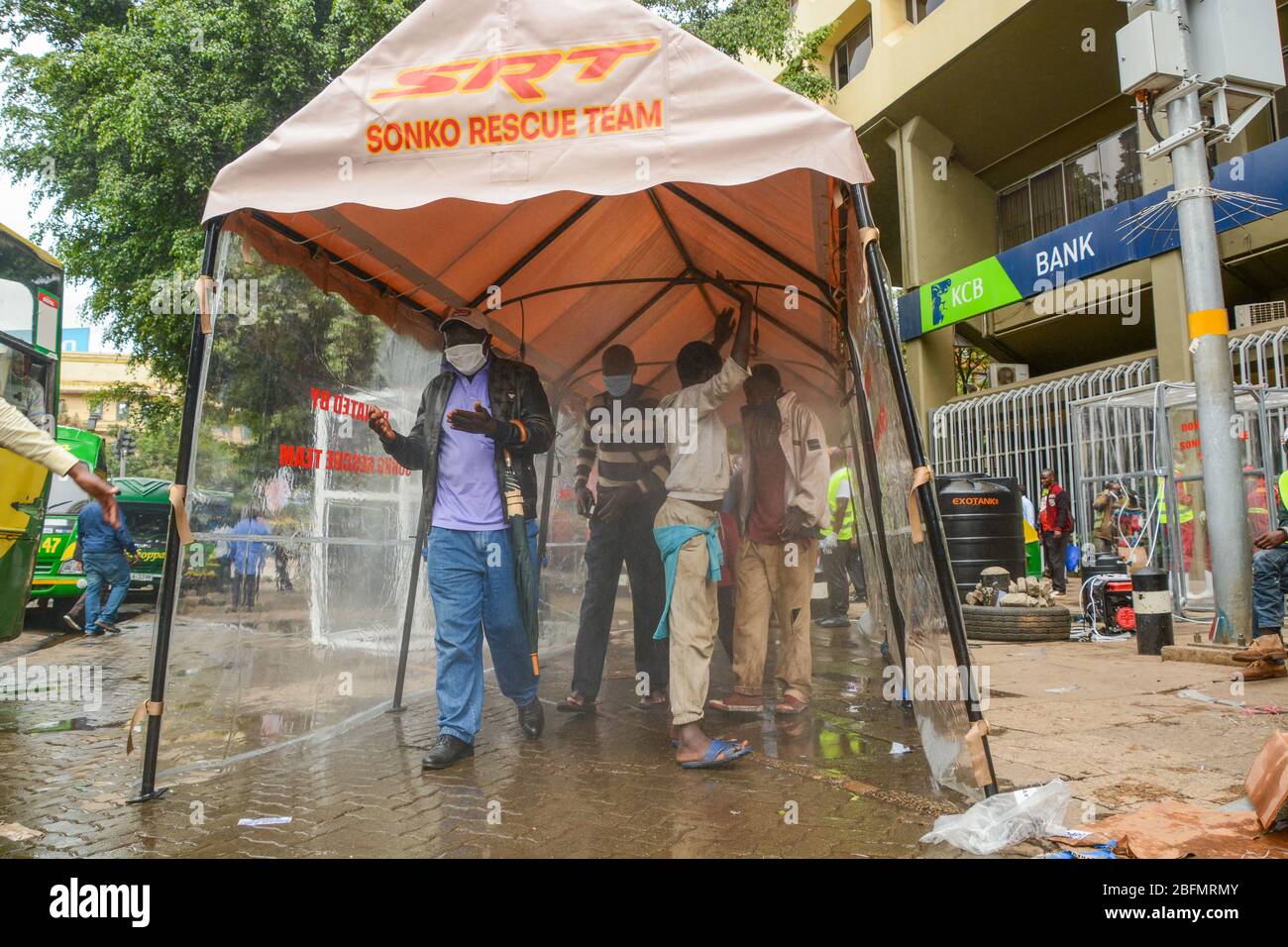 Passengers pass through a sanitiser spray booth that disinfects the ...