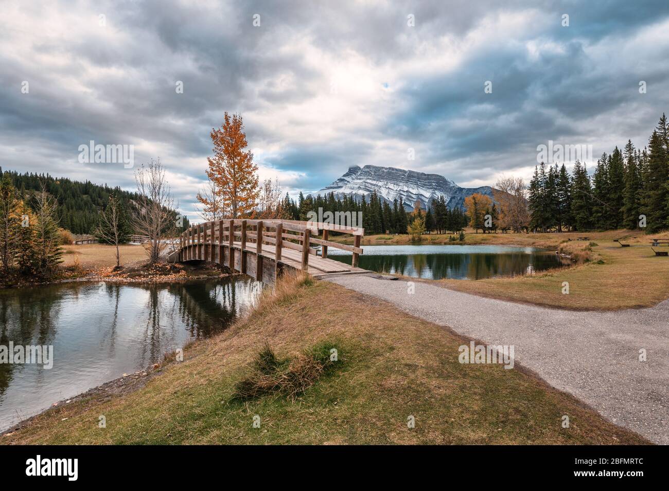 Wooden bridge with mount Rundle in autumn public park at Cascade Ponds ...