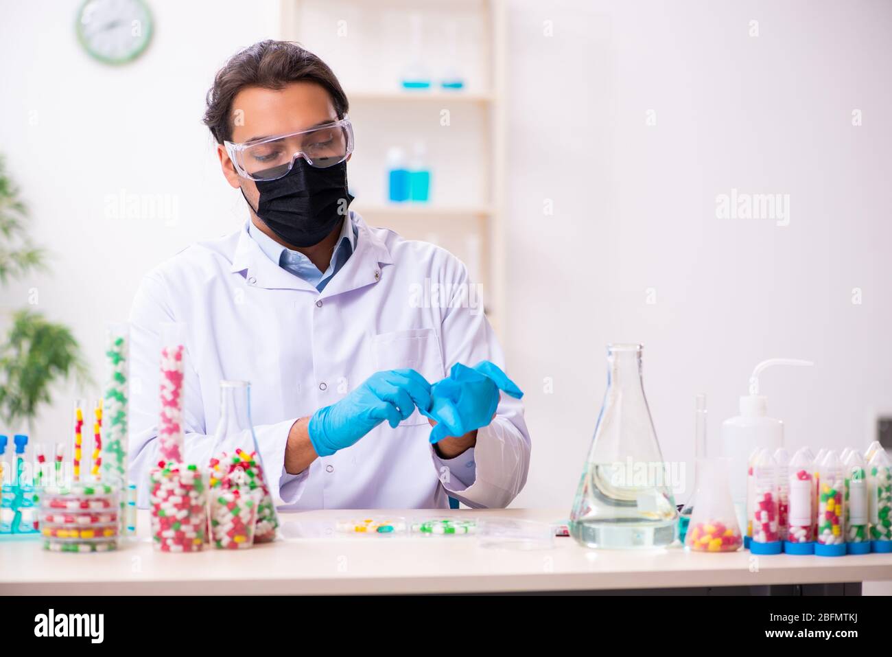 Young chemist in drug synthesis concept Stock Photo - Alamy