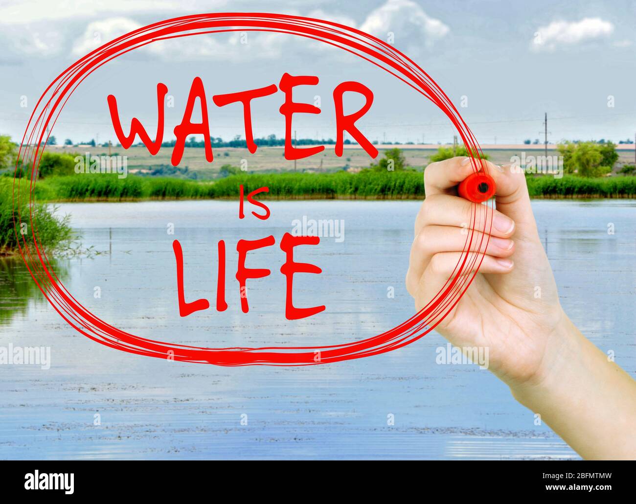 Female hand with felt-tip pen and Water is Life text on lake background ...