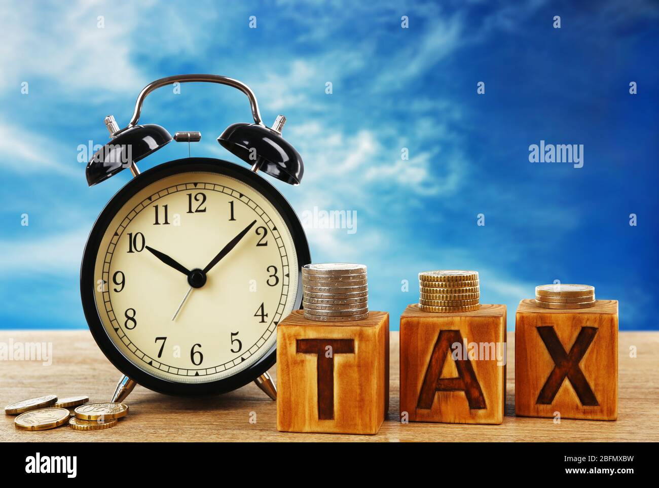 Tax concept. Tax time and alarm clock with coins on table Stock Photo ...