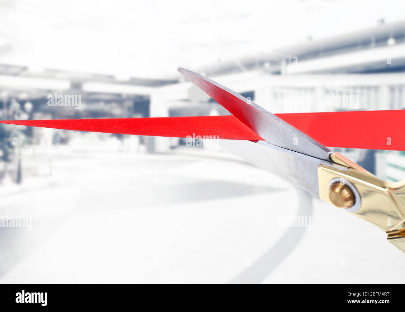Scissors cutting red ribbon close up Stock Photo - Alamy