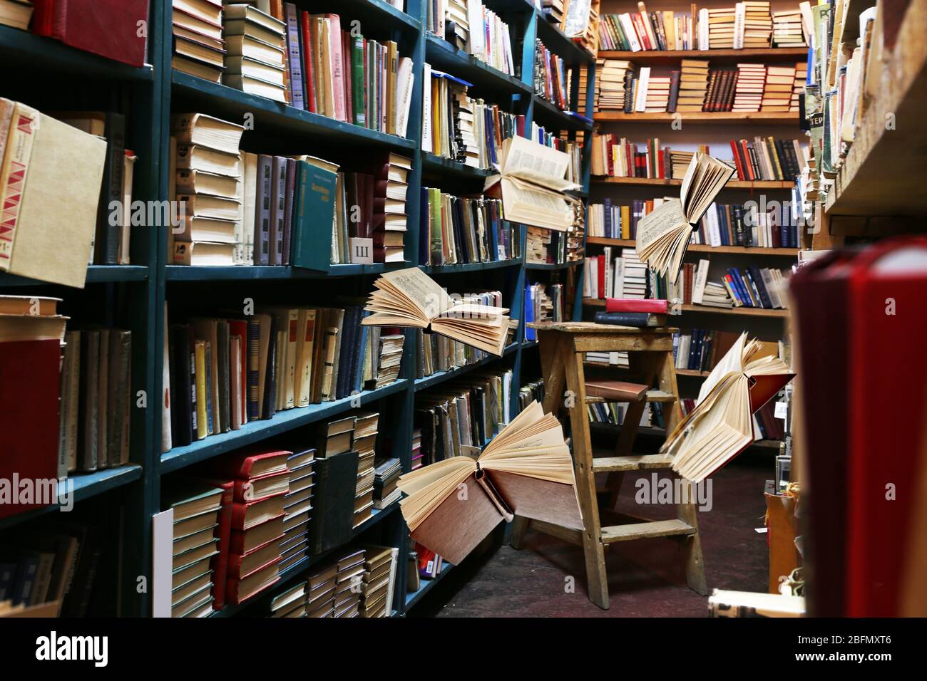 Flying books on library bookshelves background Stock Photo - Alamy