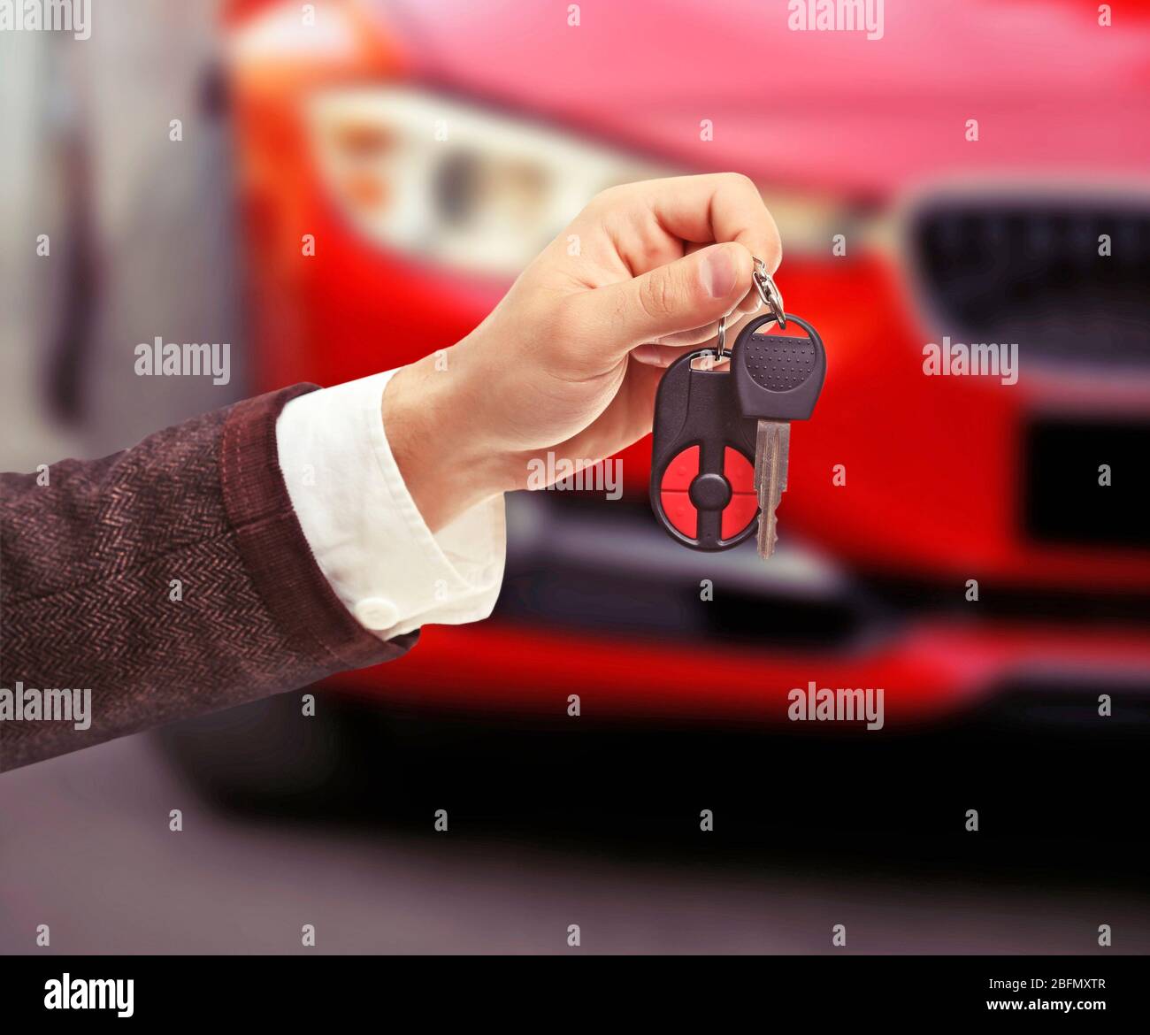 Male hand holding car keys on car background Stock Photo - Alamy