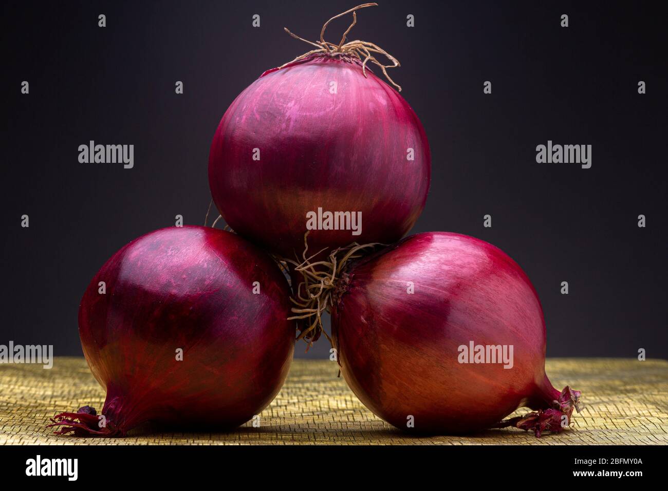 Shiny vibrant purple red onion studio low key still life macro closeup ...