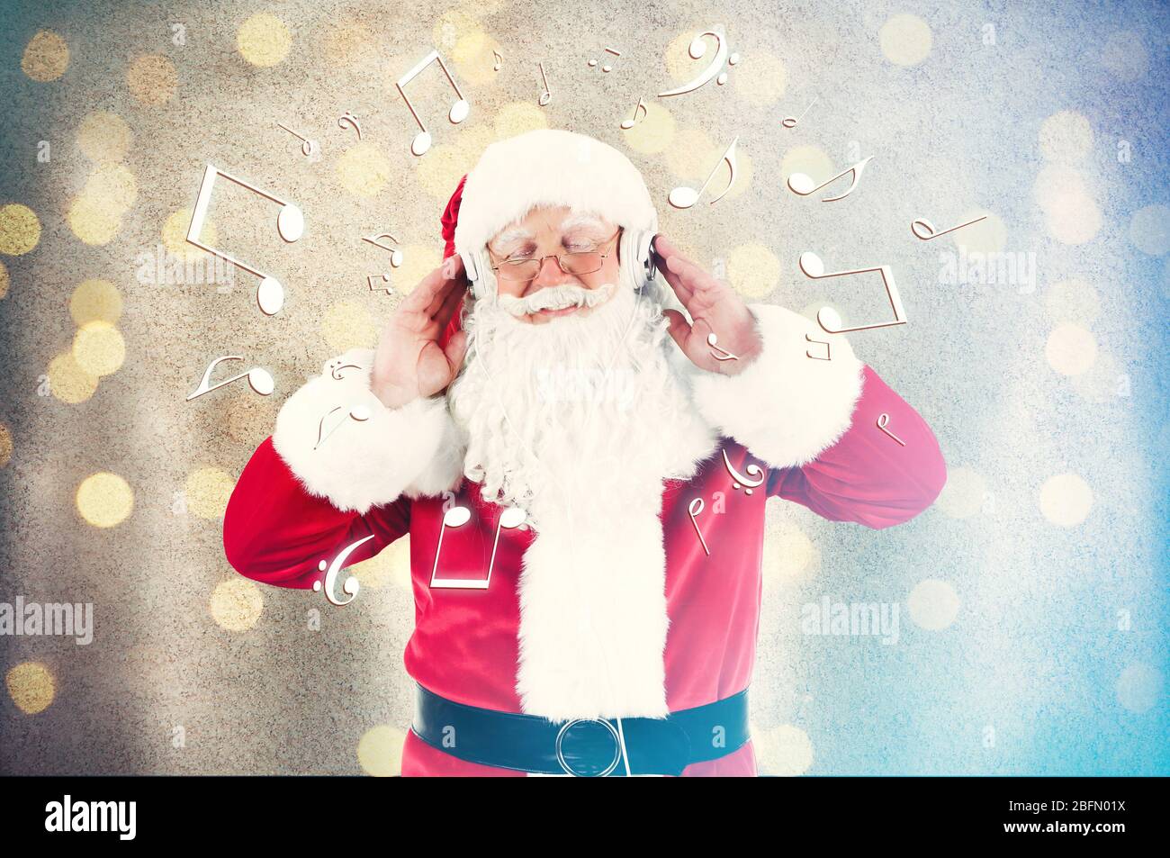 Santa Claus with headphones listening to music against bright ...