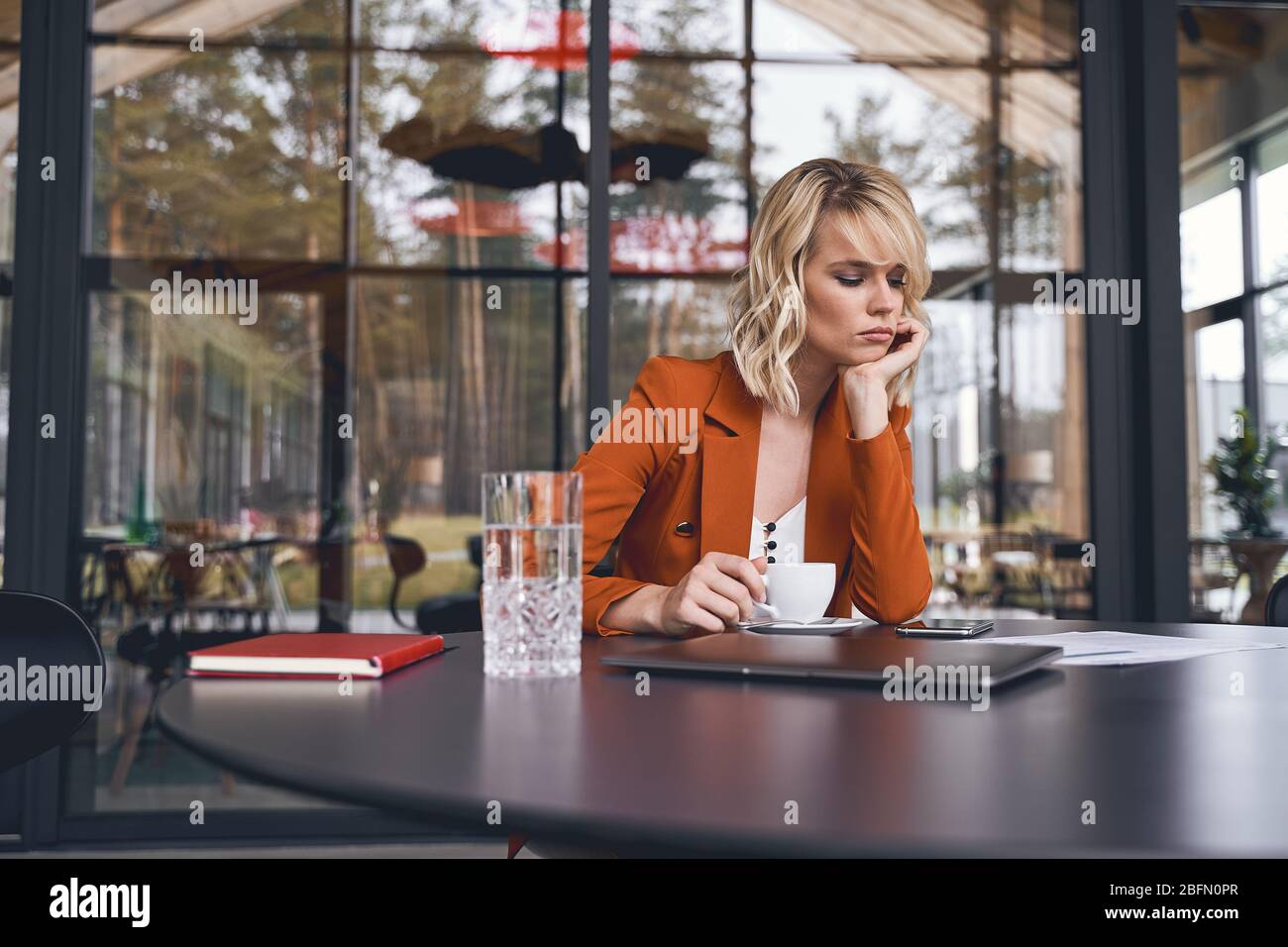 Depressed young lady sitting at the desk Stock Photo - Alamy