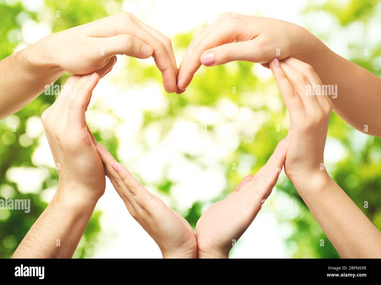 Hands in shape of heart, on blurred nature background Stock Photo - Alamy