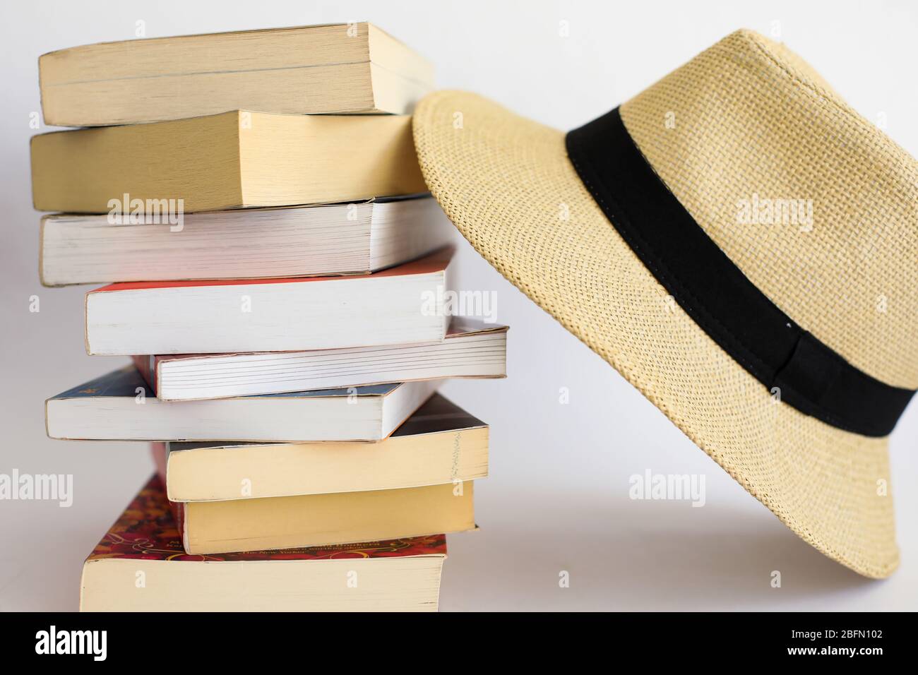 Close up of books pyramid and straw hat Stock Photo - Alamy