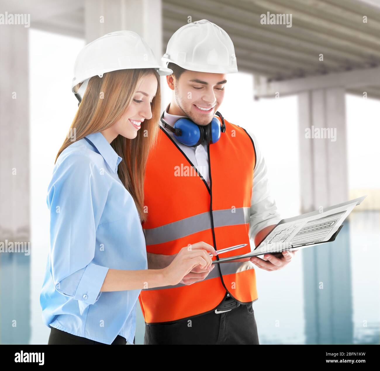 Two architects at work on blurred bridge background Stock Photo - Alamy