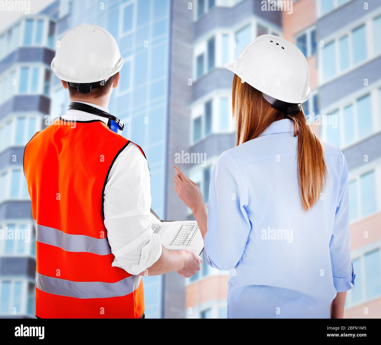 Two architects at work on blurred building background Stock Photo - Alamy