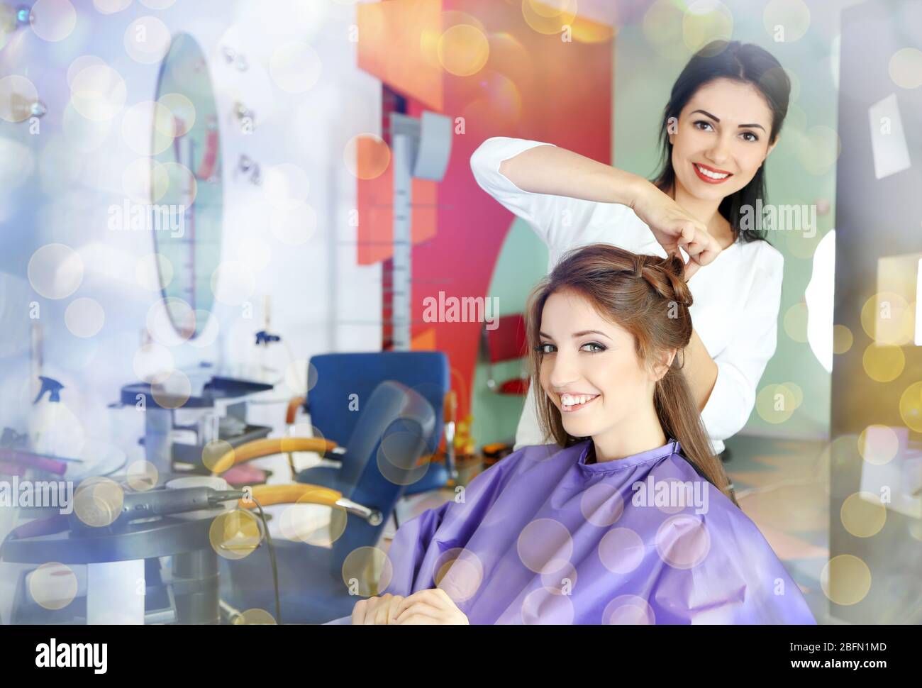 Young woman hairdresser do hairstyle girl in beauty salon, over blurred ...