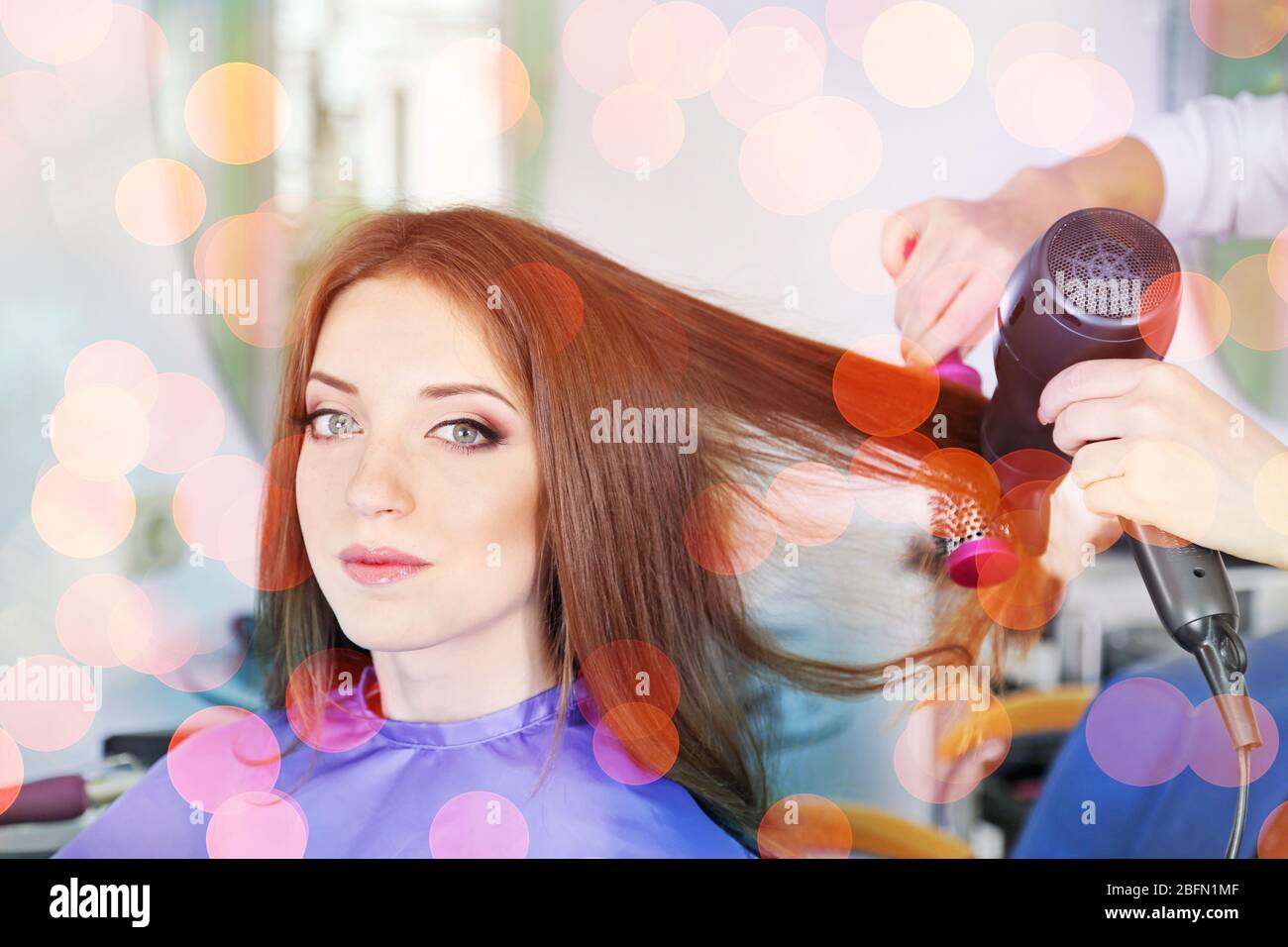 Young woman hairdresser do hairstyle girl in beauty salon, over blurred ...