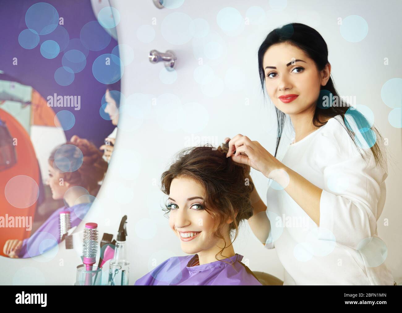 Young woman hairdresser do hairstyle girl in beauty salon, over blurred ...