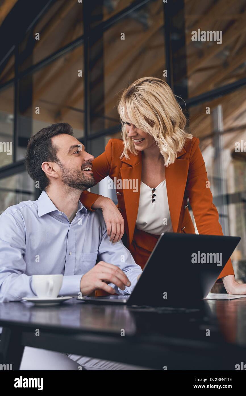 Two office workers smiling at each other Stock Photo - Alamy