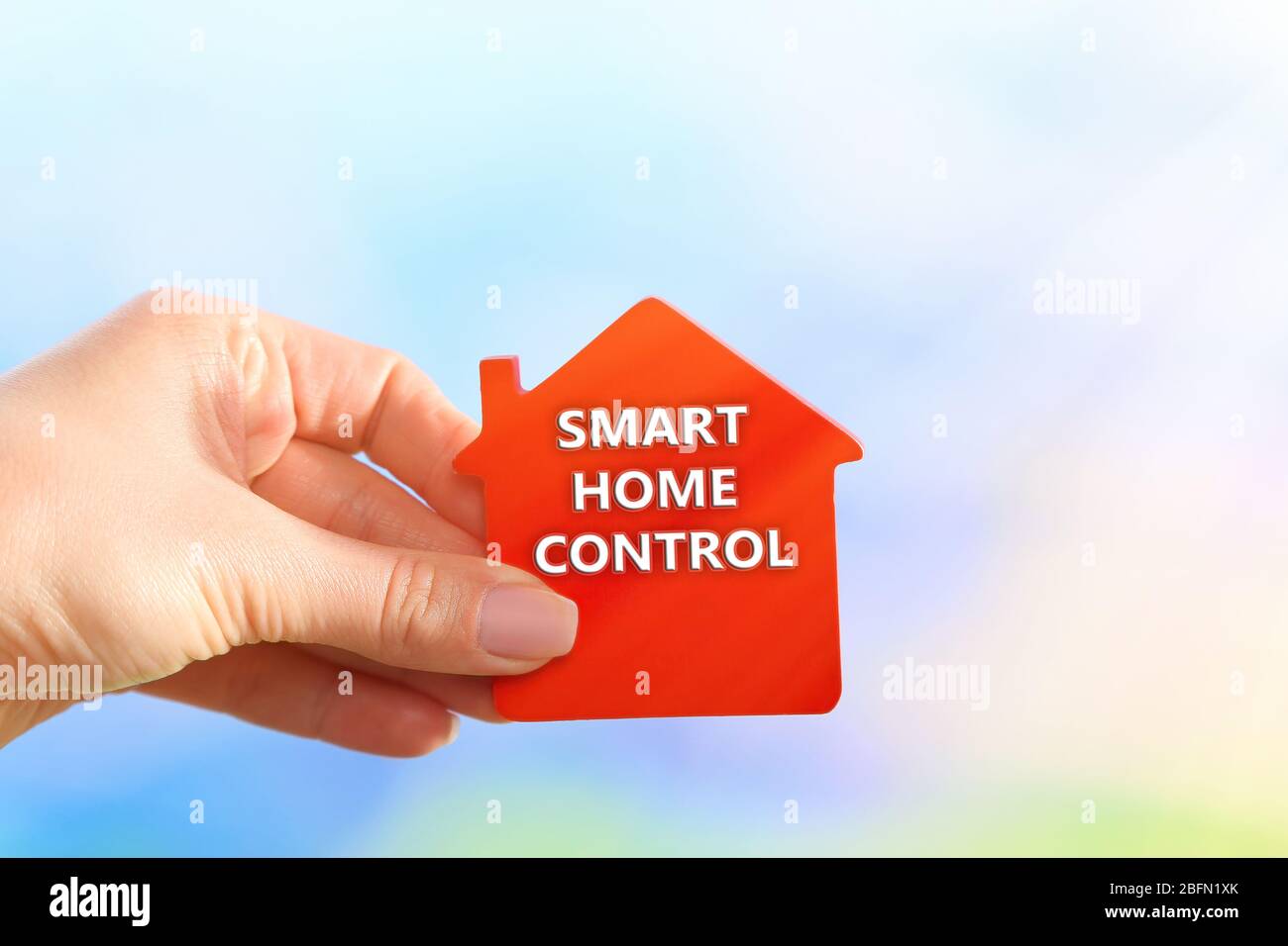 Smart home technology concept. Female hand holding model of house on ...