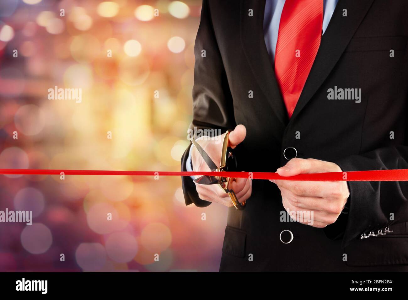 Businessman cutting red ribbon with pair of scissors close up Stock ...