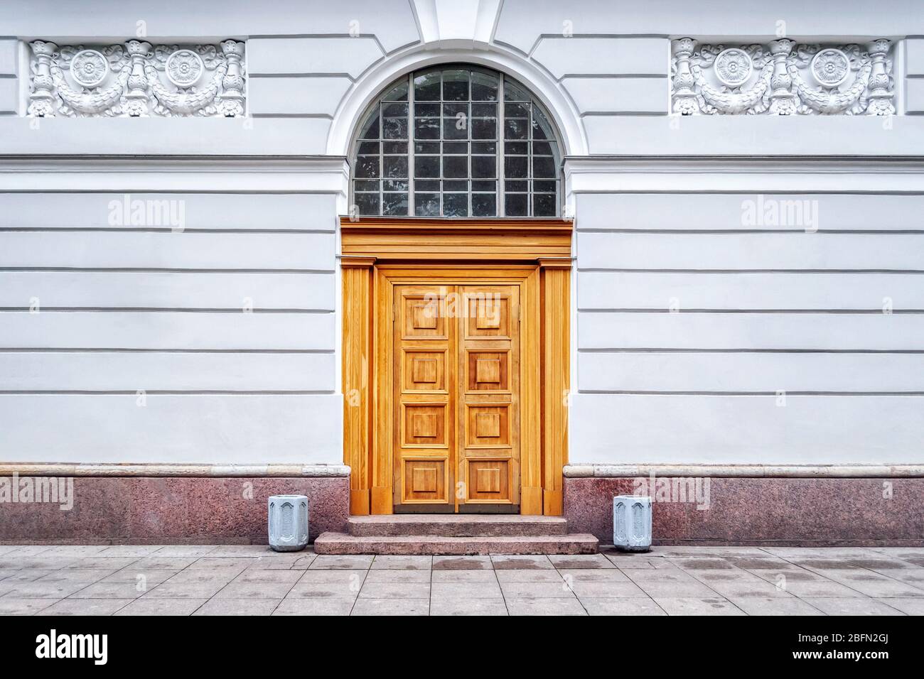 Entrance arched doors on the background of a gray wall with stucco and ...