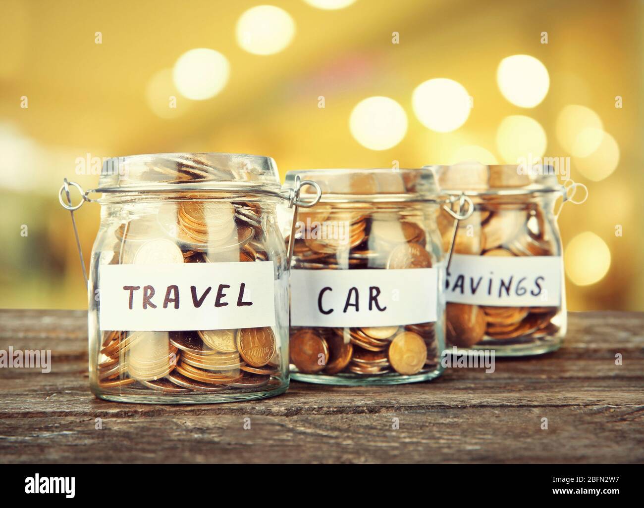 Three jars for different needs full of coins on bright background Stock ...