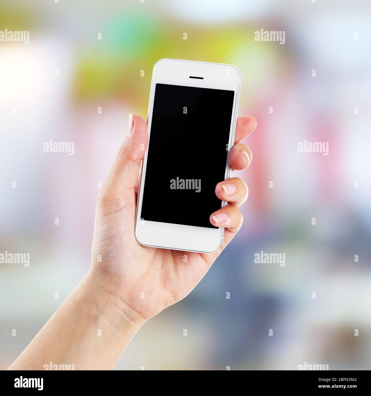 Hand shows mobile smart phone, blurred background Stock Photo - Alamy