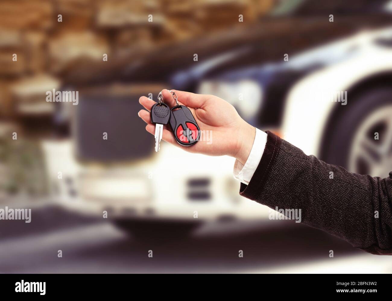 Male hand holding car keys on car background Stock Photo - Alamy