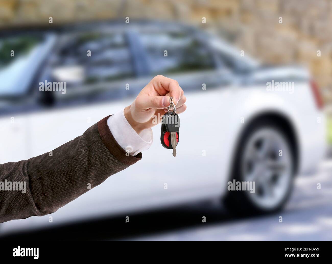 Male hand holding car keys on car background Stock Photo - Alamy