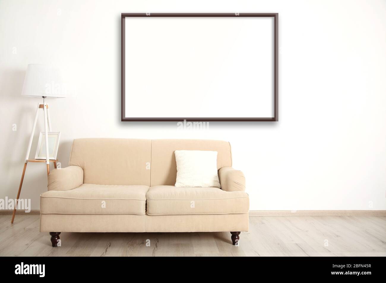 Beige couch with lamp and empty picture frame on wall background Stock ...