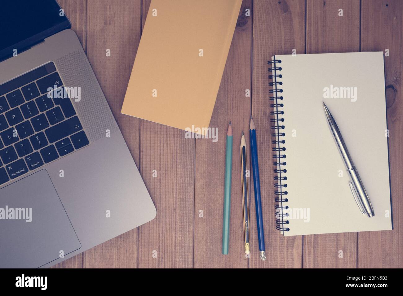 Wooden office desk table with laptop, pencil and notepad. home or ...