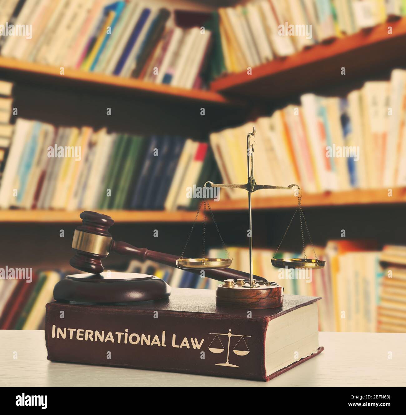 Wooden gavel with justice scales on table in library Stock Photo - Alamy
