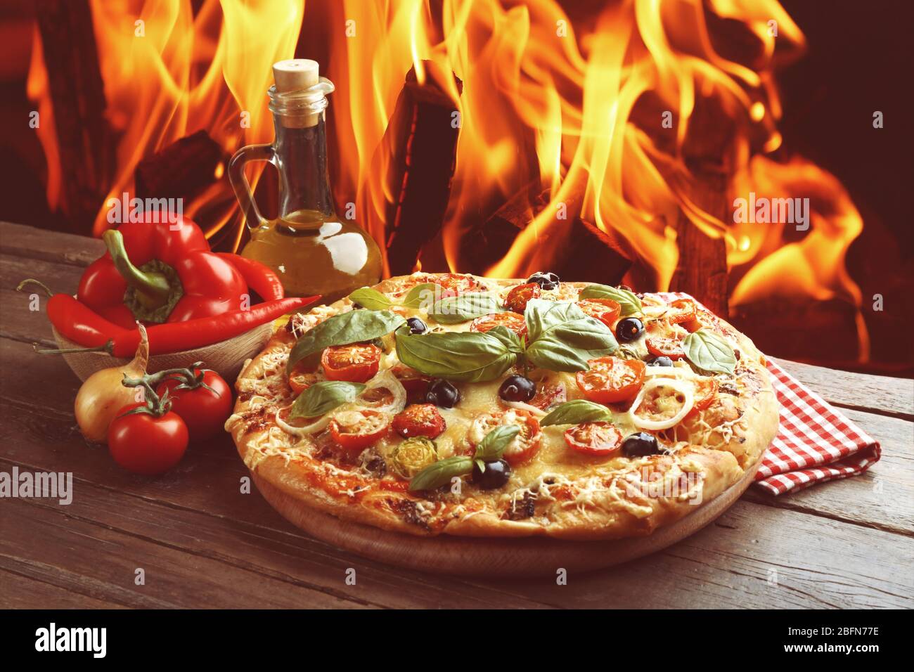 Delicious fresh pizza on fire flame background Stock Photo - Alamy