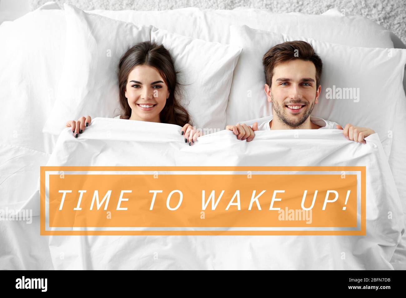 Text Time to wake up and young cute couple lying together in bed Stock ...