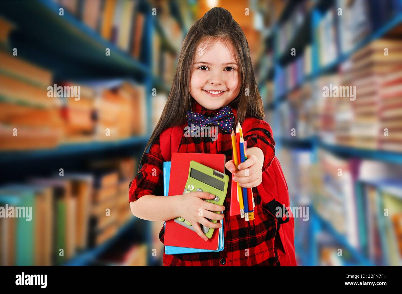 Girl with books in school library Stock Photo - Alamy