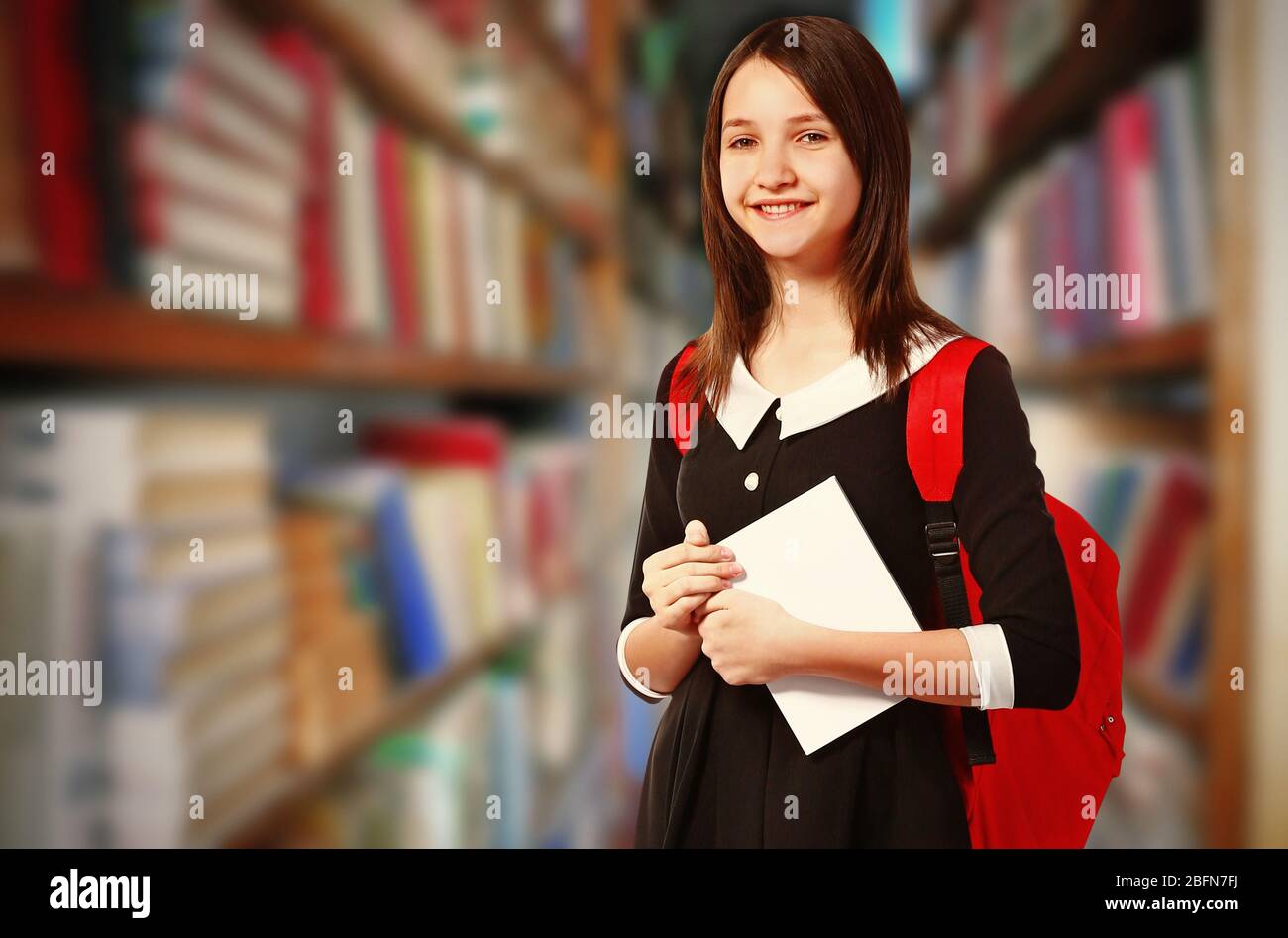 Girl with books in school library Stock Photo - Alamy