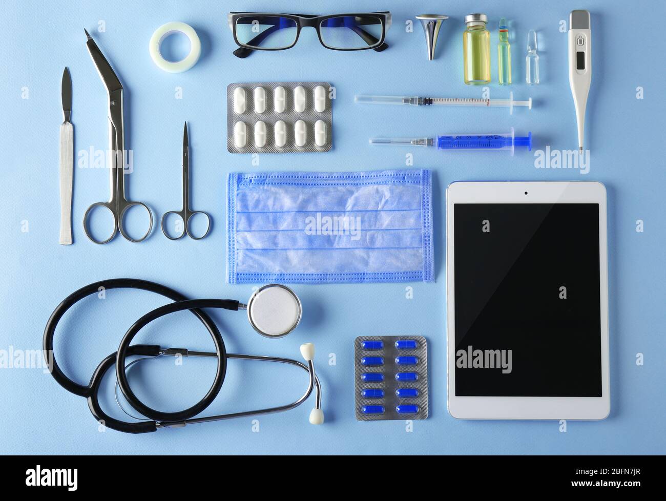 Doctor table with medical items on blue background. Flat lay Stock ...