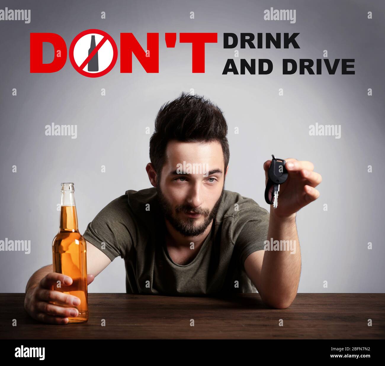 Drunk young man with car key and beer bottle at bar. Text DON'T DRINK ...