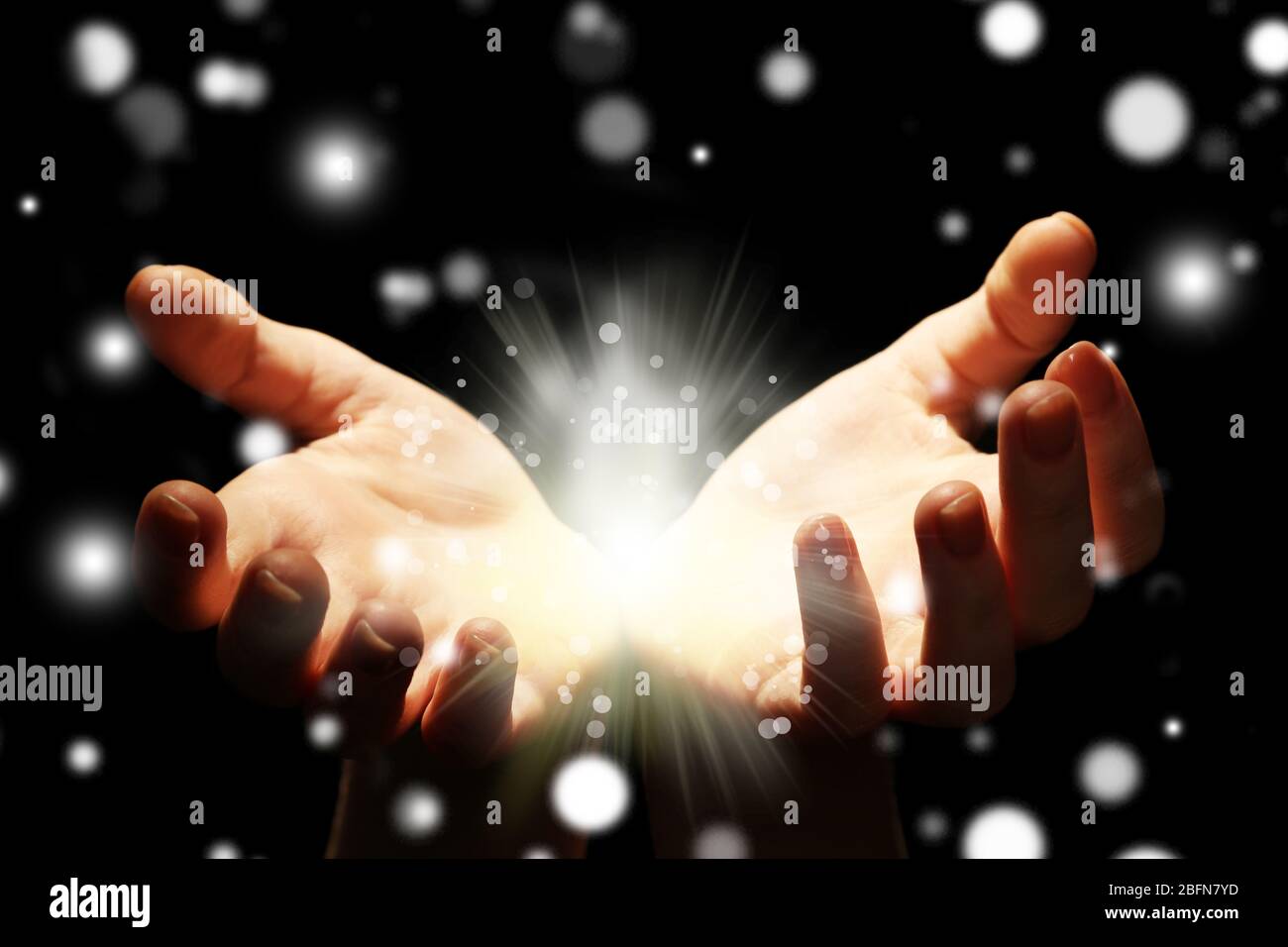 Female hands holding light in dark, closeup. Snowy effect, Christmas ...