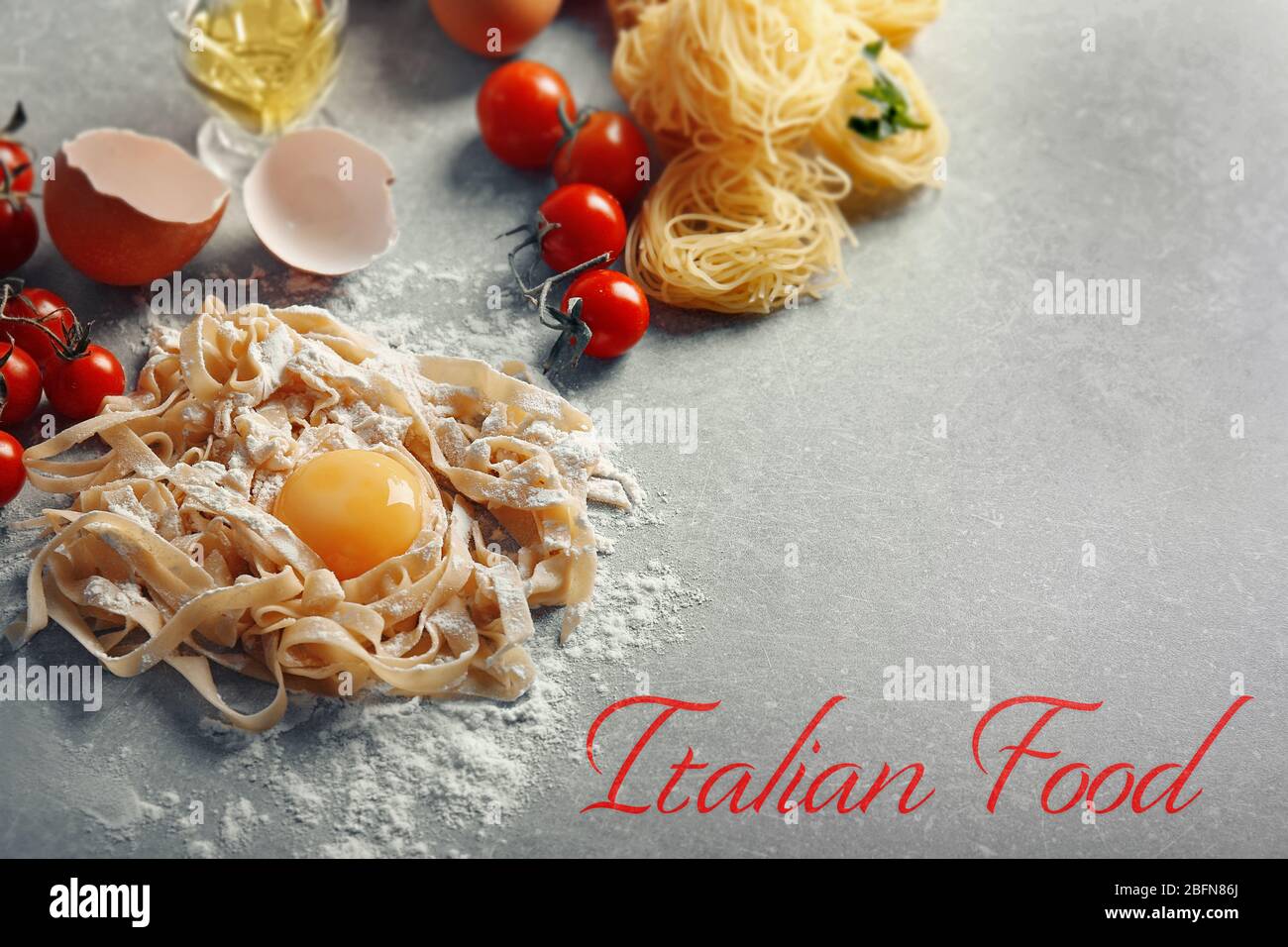 Homemade pasta with yolk on table. Text ITALIAN FOOD on gray background ...
