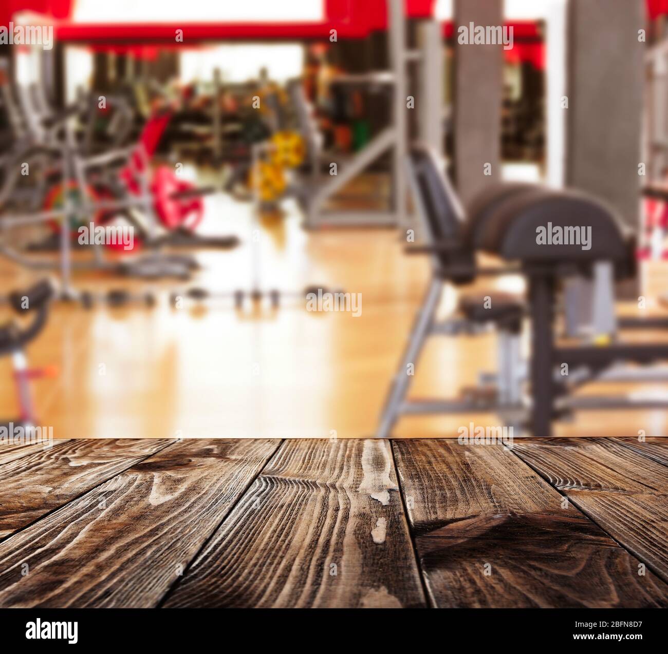 Wooden table against blurred gym interior background. Sport and ...