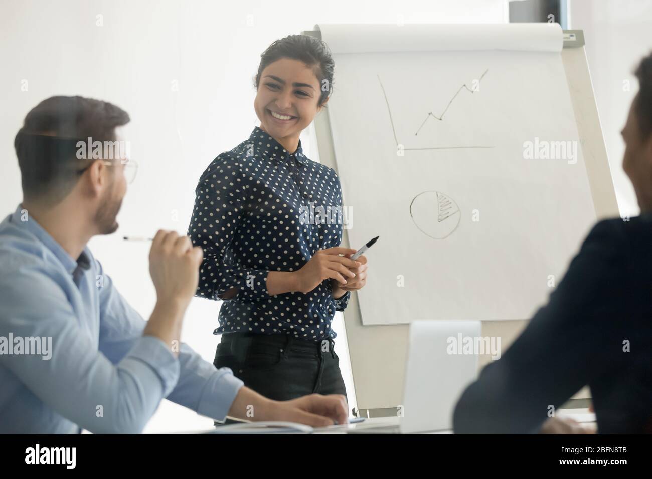 Millennial smiling indian coach interacting with corporate training participants Stock Photo - Alamy