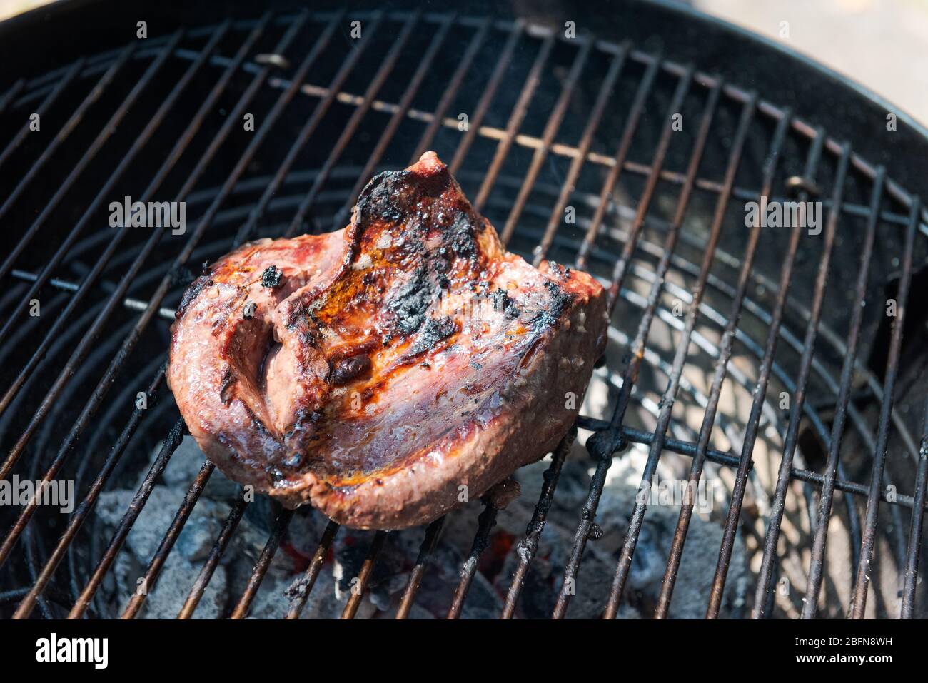 Big piece of roasted beef heart on charcoal bbq cooking grate Stock ...