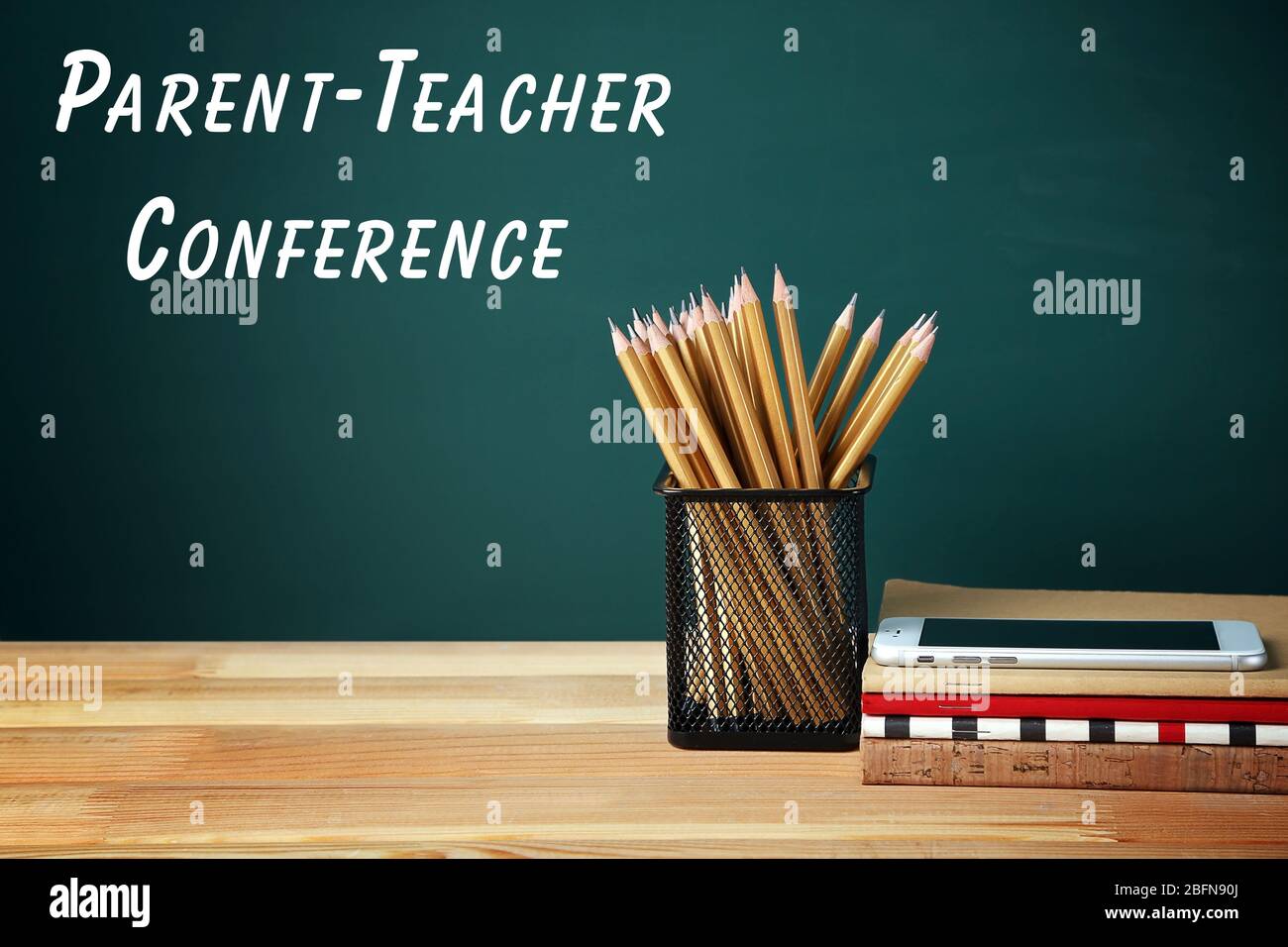 Stationary and smartphone on wooden table. Text PARENT-TEACHER ...