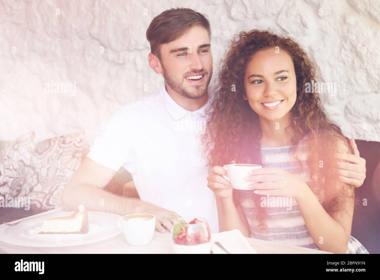 Young couple with drink in cafe. View through window glass effect Stock ...