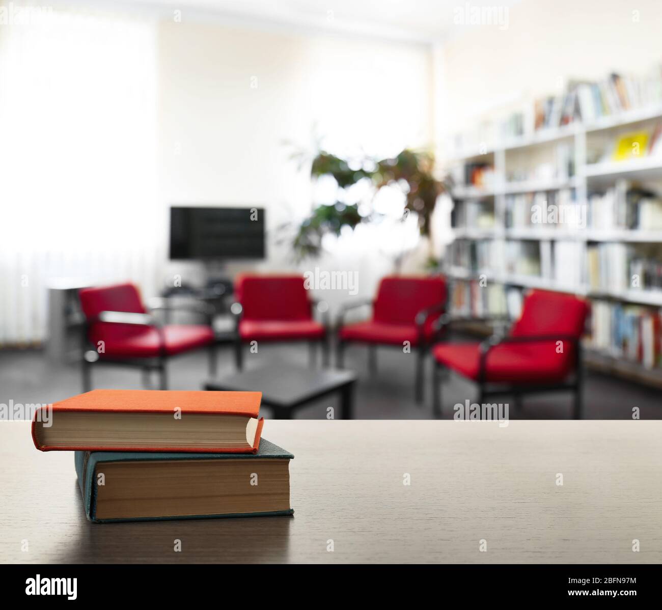 Books on table at library Stock Photo - Alamy