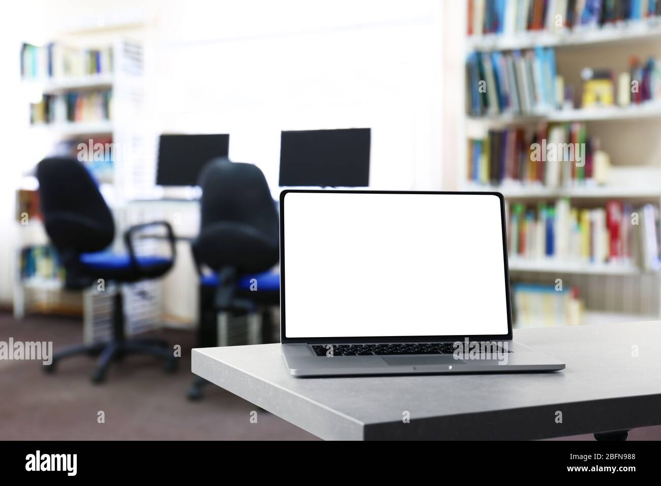 Modern laptop on table at library Stock Photo - Alamy