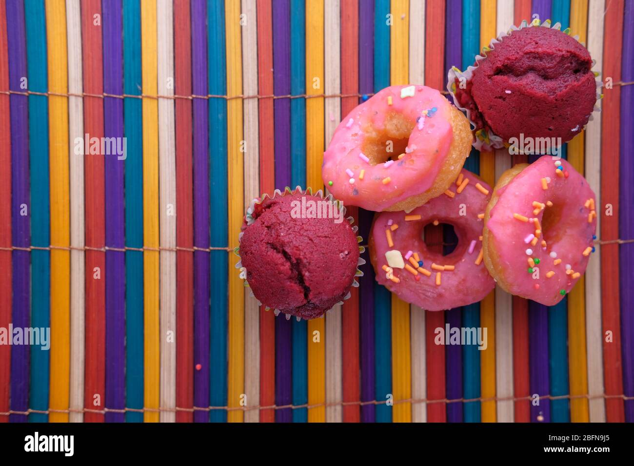 Close up of colorful donuts on wooden table Stock Photo - Alamy
