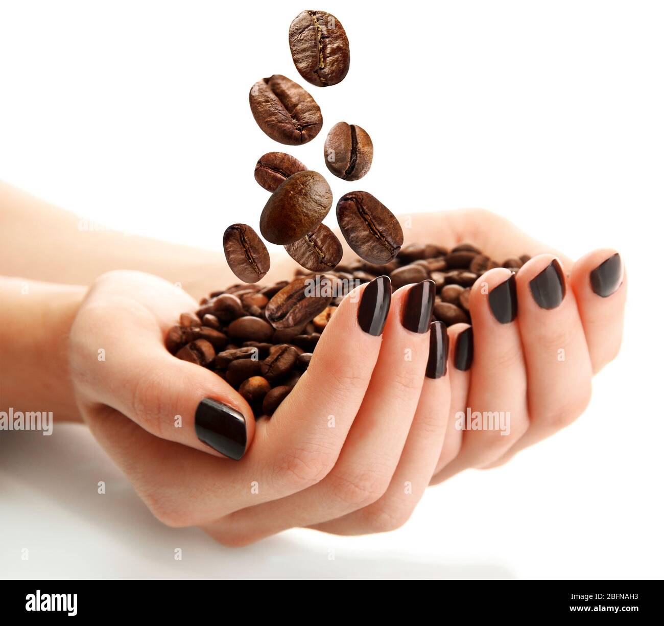 Roasted coffee beans falling into female hands on white background ...